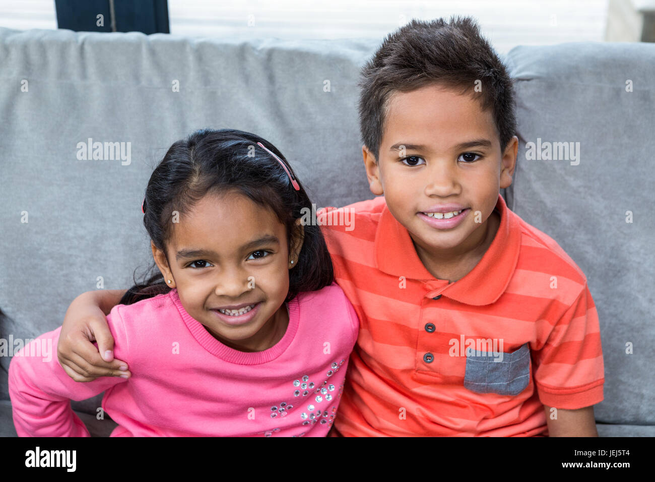 Smiling siblings looking at the camera Stock Photo - Alamy