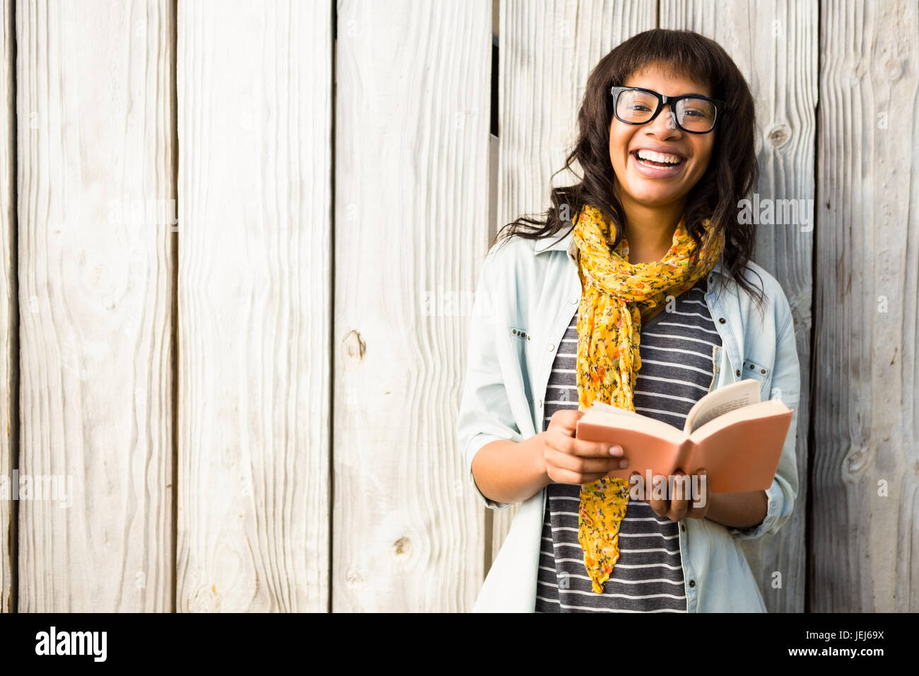 Smiling casual woman reading a book Stock Photo - Alamy