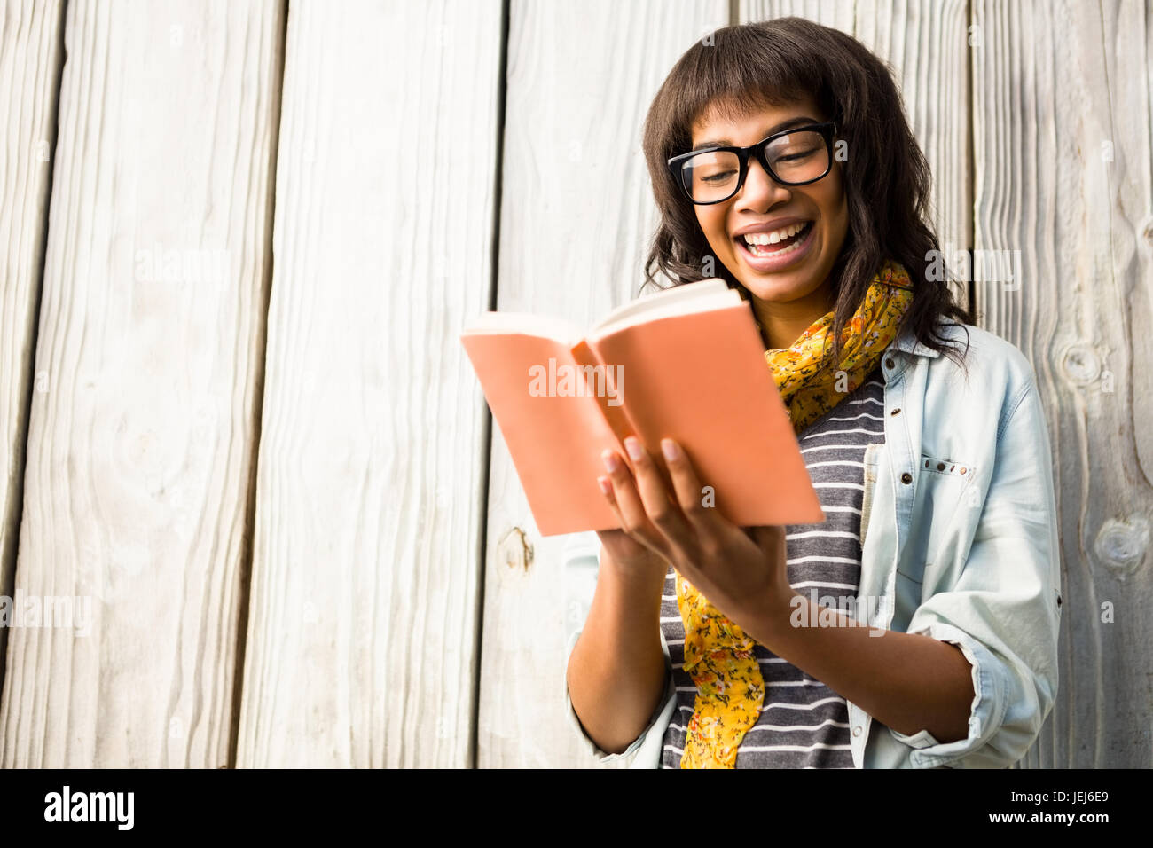 Smiling casual woman reading a book Stock Photo - Alamy