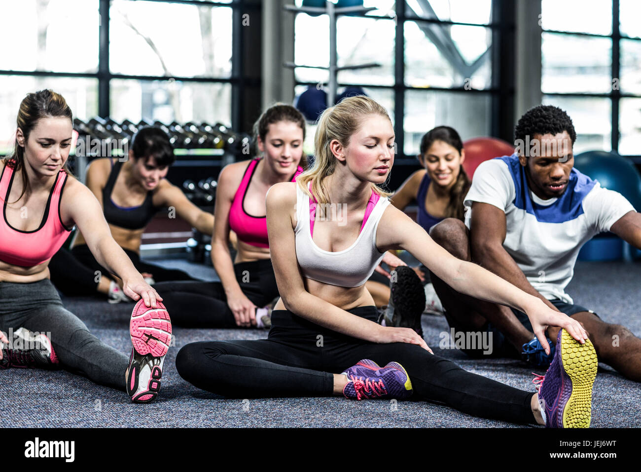 Fit smiling group doing stretching Stock Photo - Alamy