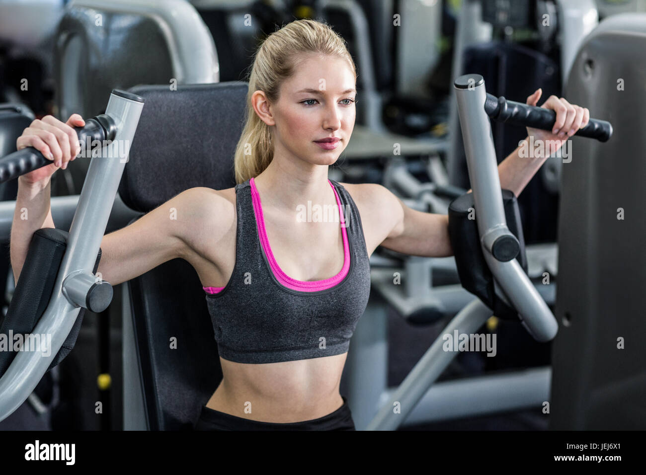 Fit woman using exercise machine Stock Photo - Alamy