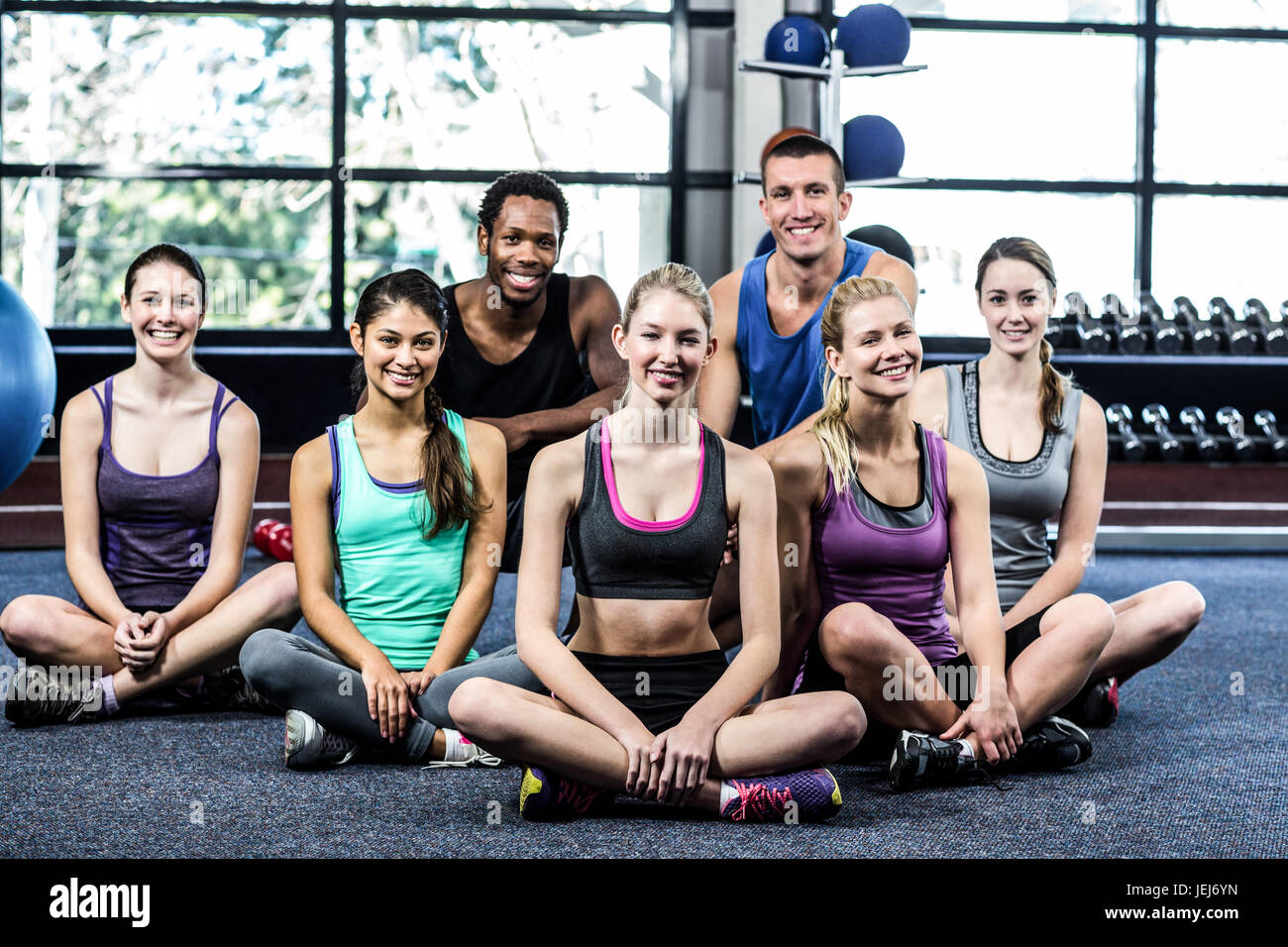 Smiling fitness class posing together Stock Photo - Alamy
