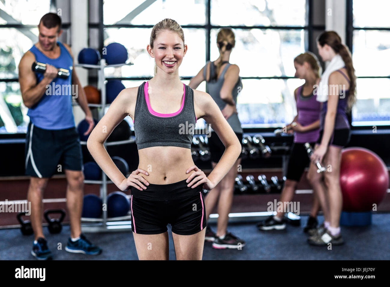 Smiling woman posing with hands on hips Stock Photo - Alamy