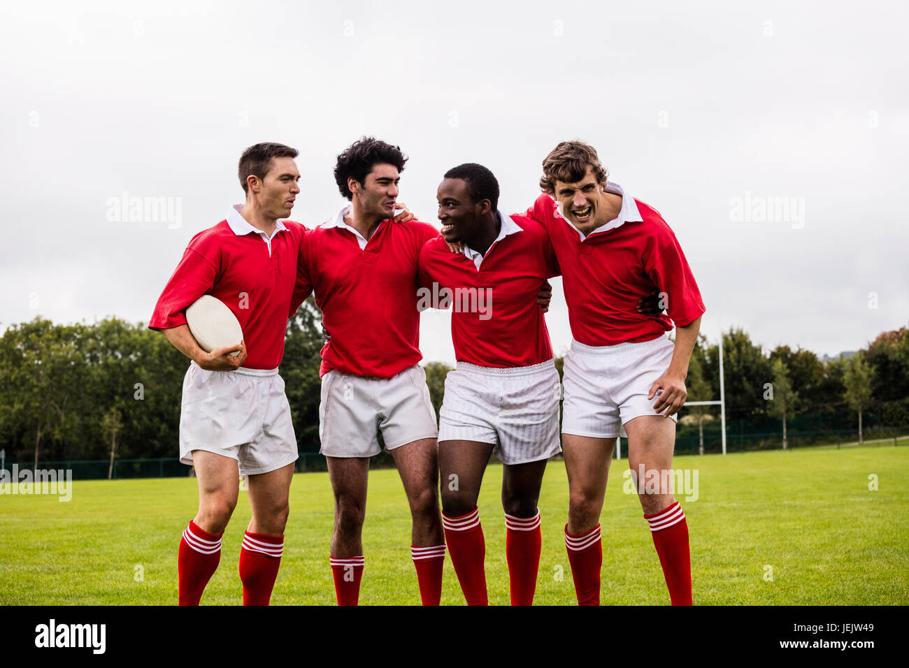 Rugby players smiling with arms around Stock Photo - Alamy