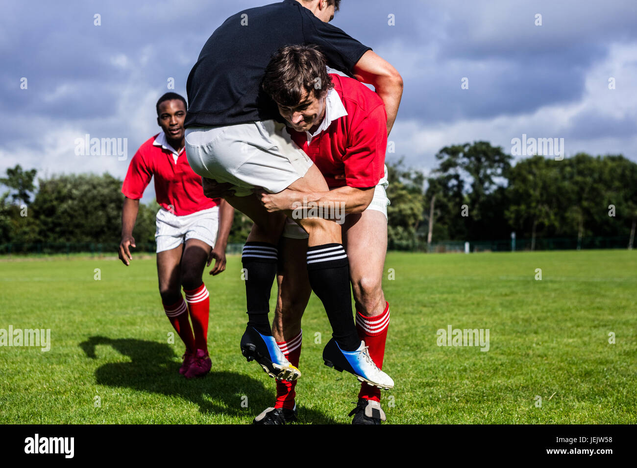 Rugby players tackling during game Stock Photo - Alamy