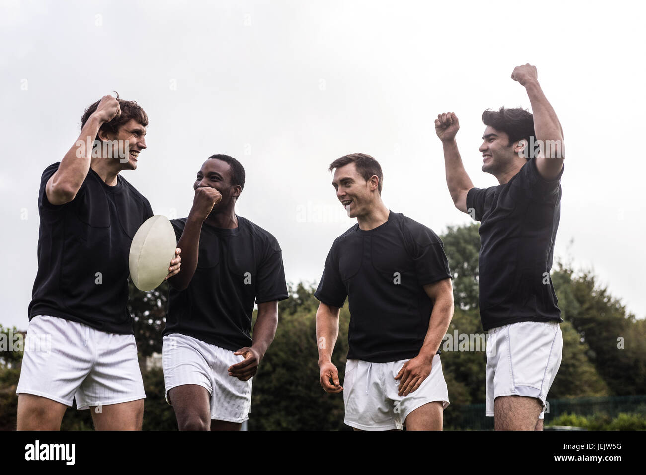 Rugby players cheering together with ball Stock Photo - Alamy