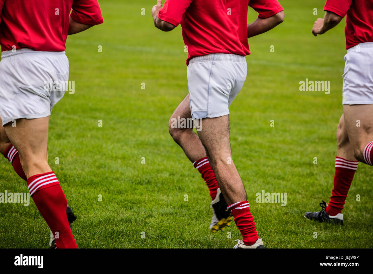 Rugby players jogging on pitch Stock Photo - Alamy