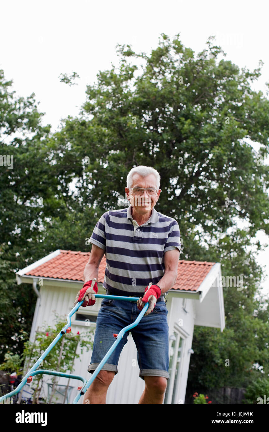 Senior man mowing lawn Stock Photo - Alamy
