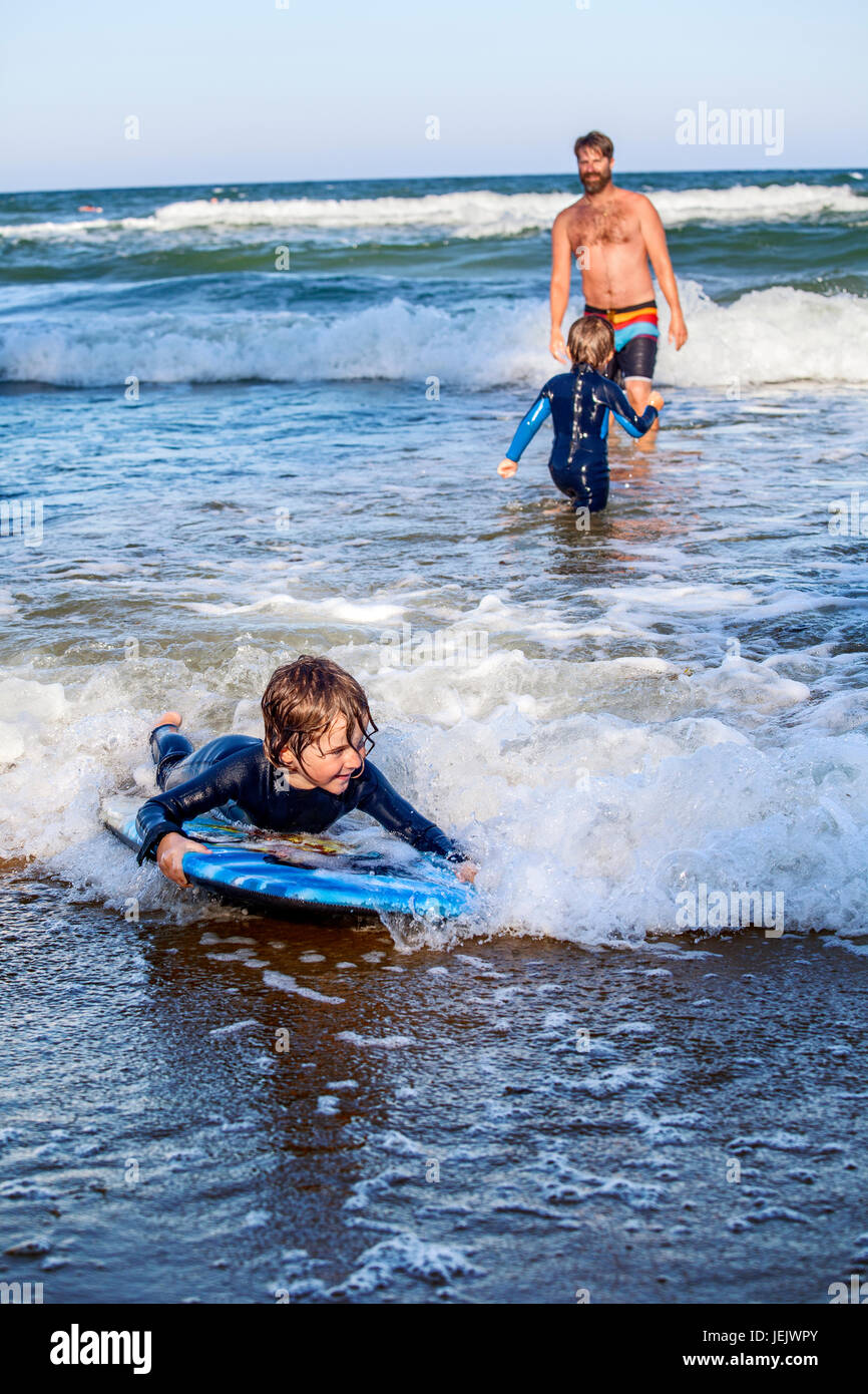 Father with sons surfing Stock Photo - Alamy