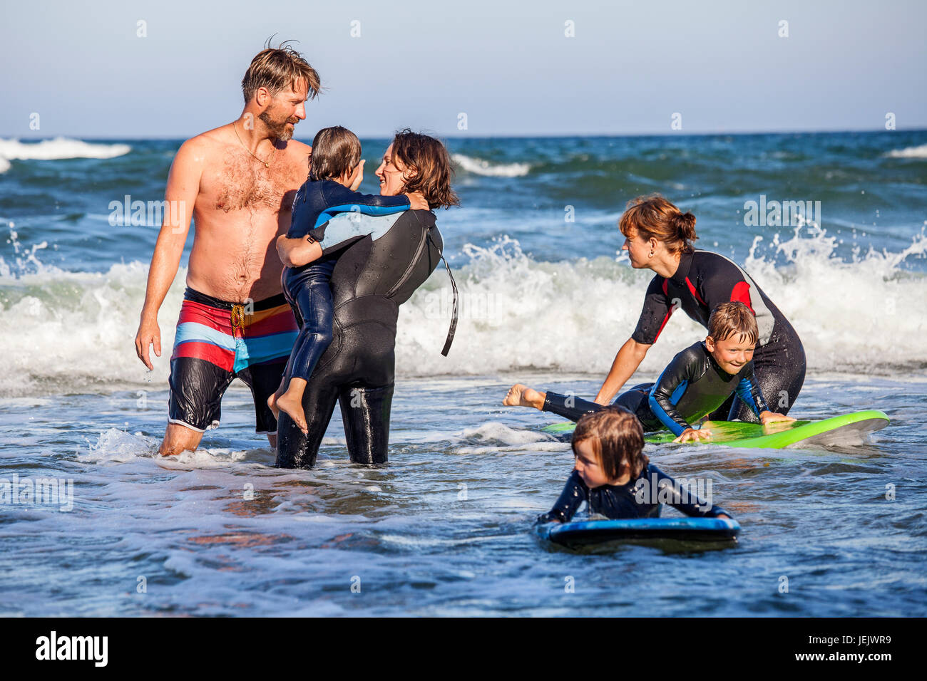 Parents with children surfing Stock Photo - Alamy