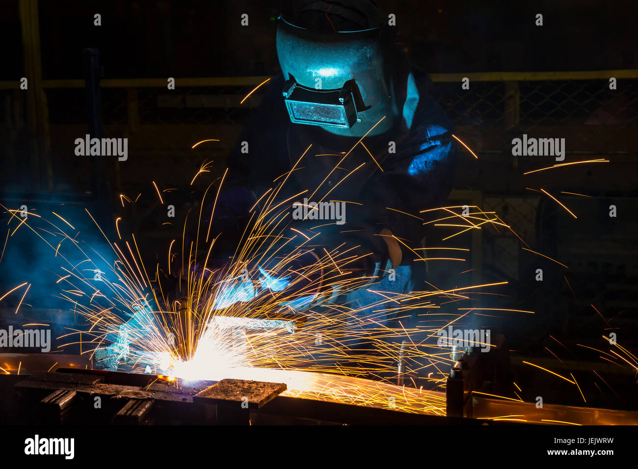 Industrial worker is welding assembly part in car factory Stock Photo ...
