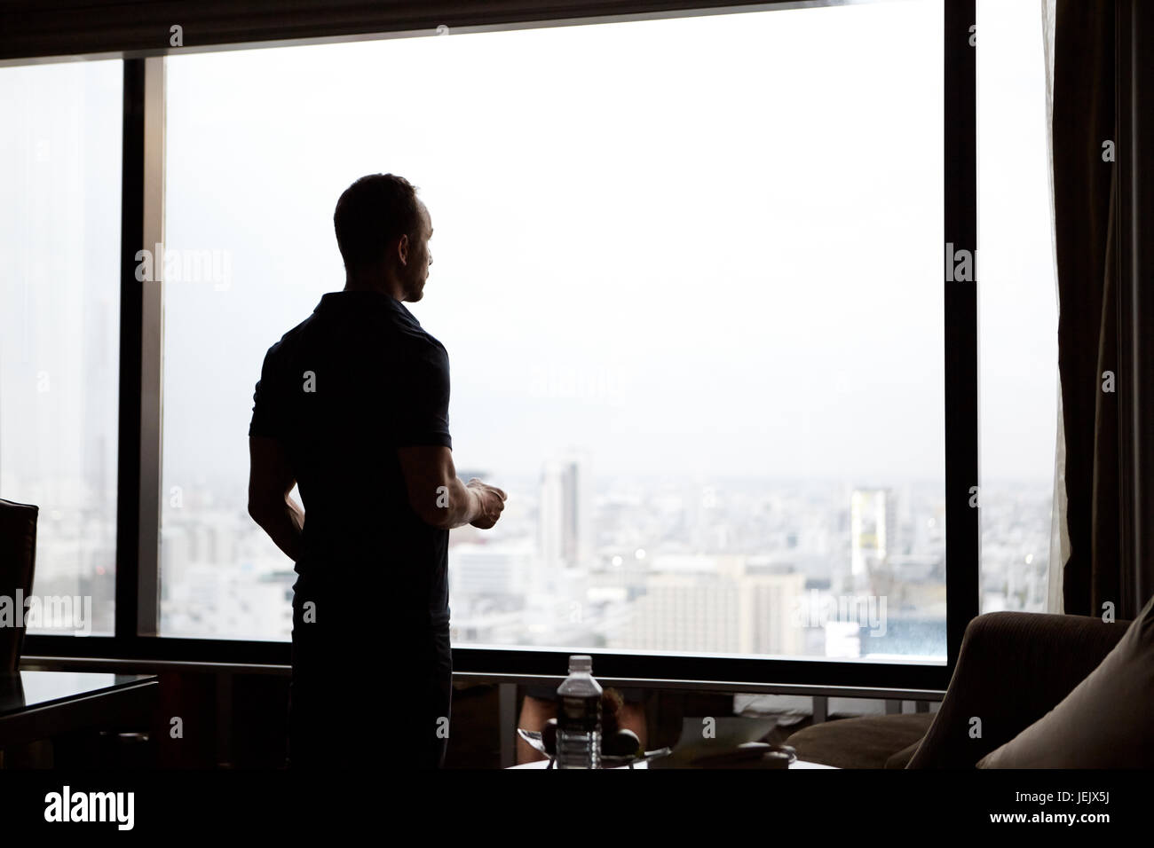Man looking through window at cityscape Stock Photo - Alamy