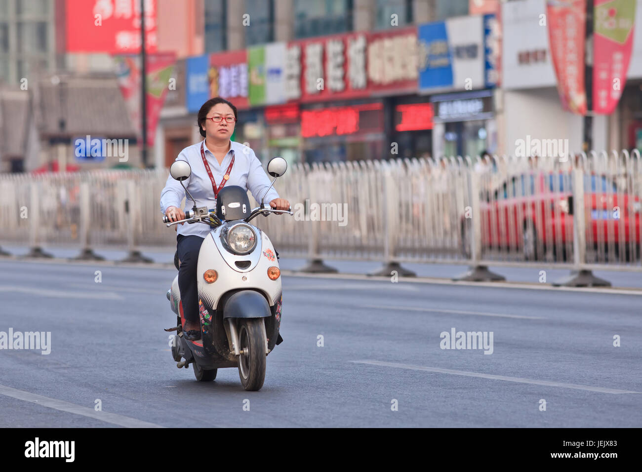 BEIJING-JULY 10, 2015. Woman on an e-bike. In a decade, e-bikes in ...