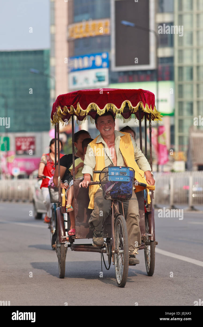 BEIJING-JULY 24, 2015. Cheerful rickshaw driver with passengers. In ...