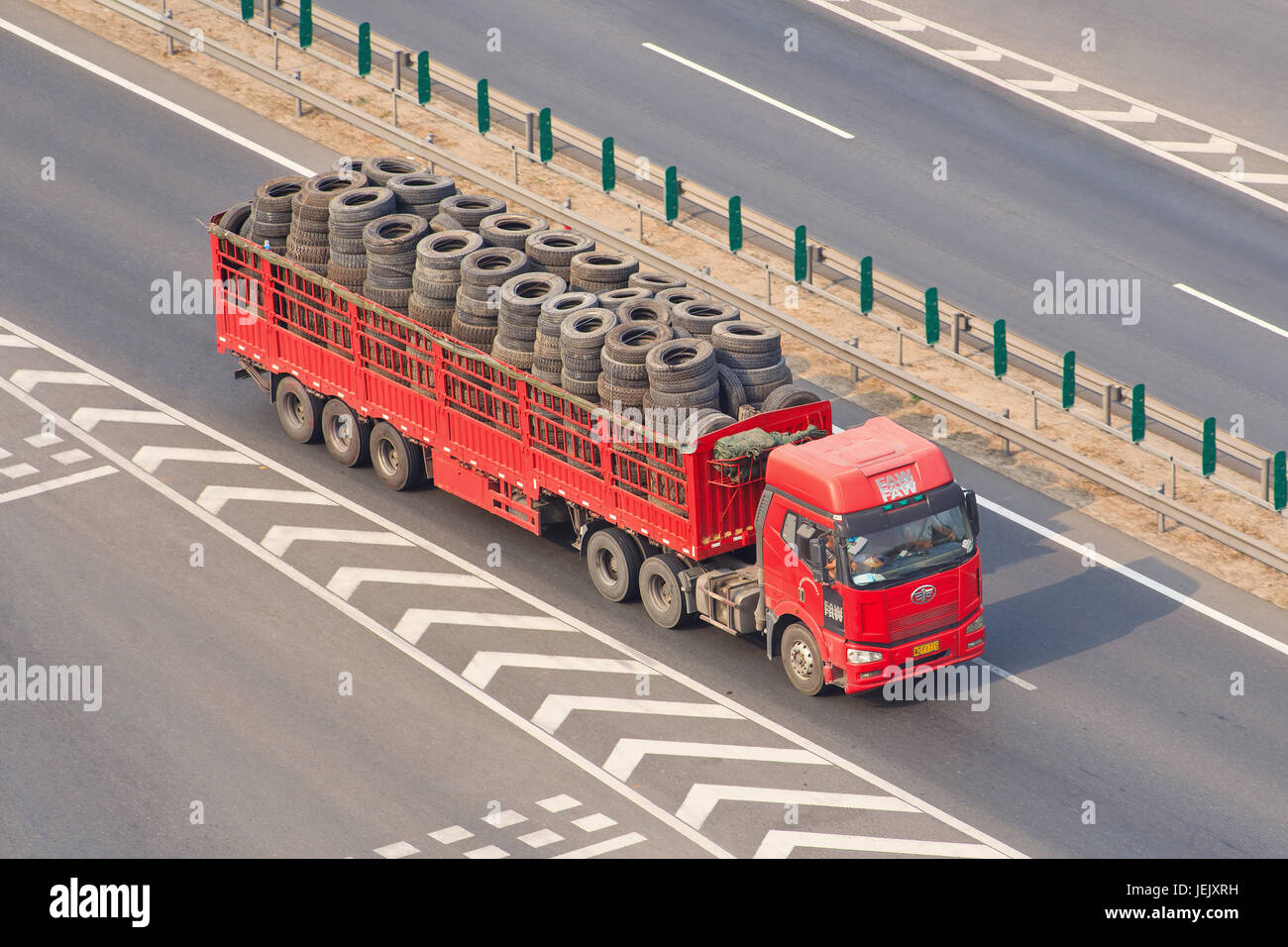 BEIJING-JULY 10, 2015. FAW truck with trailer loaded with tires. FAW ...