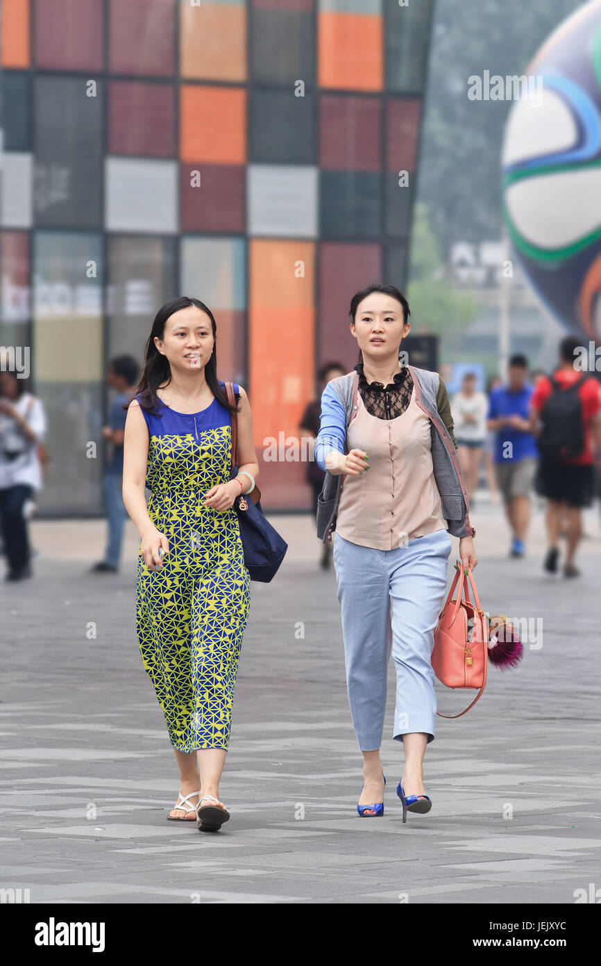 BEIJING-JUNE 25, 2014. Young women in shopping area. China’s economy ...