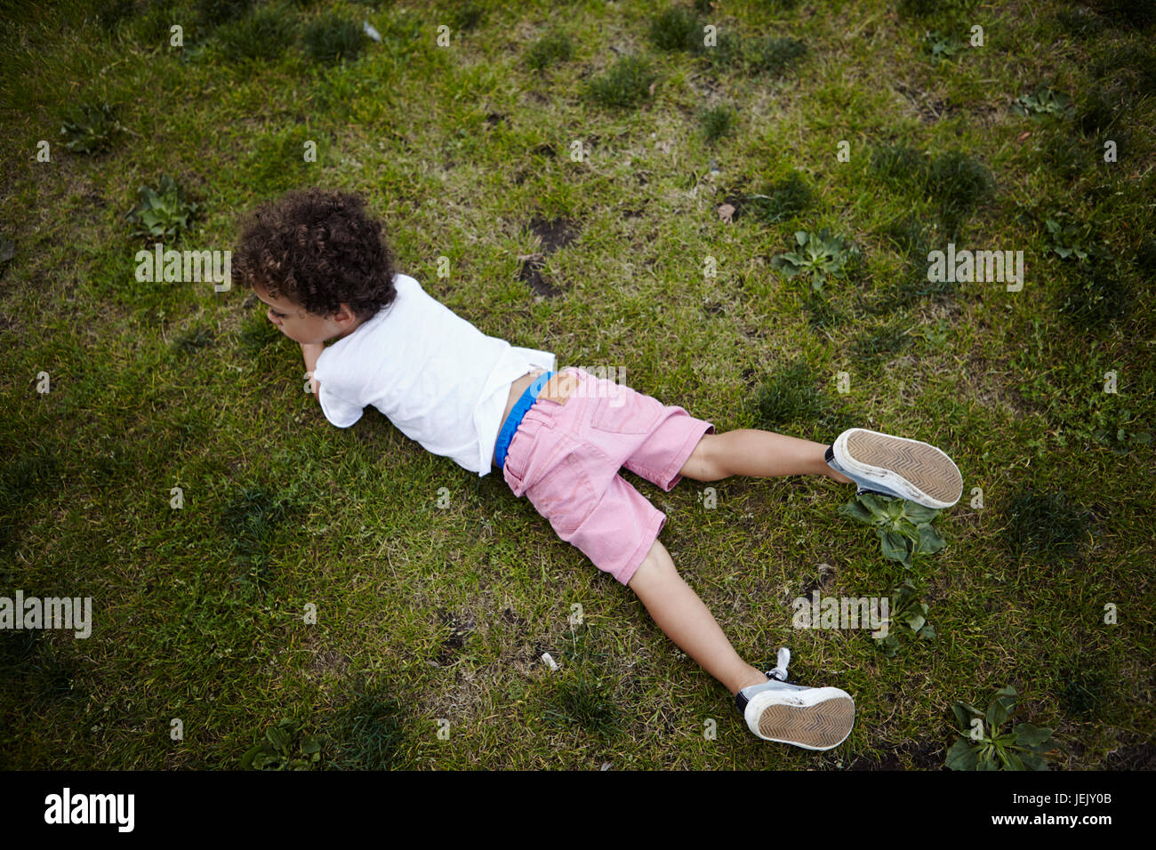 Boy lying on grass Stock Photo - Alamy