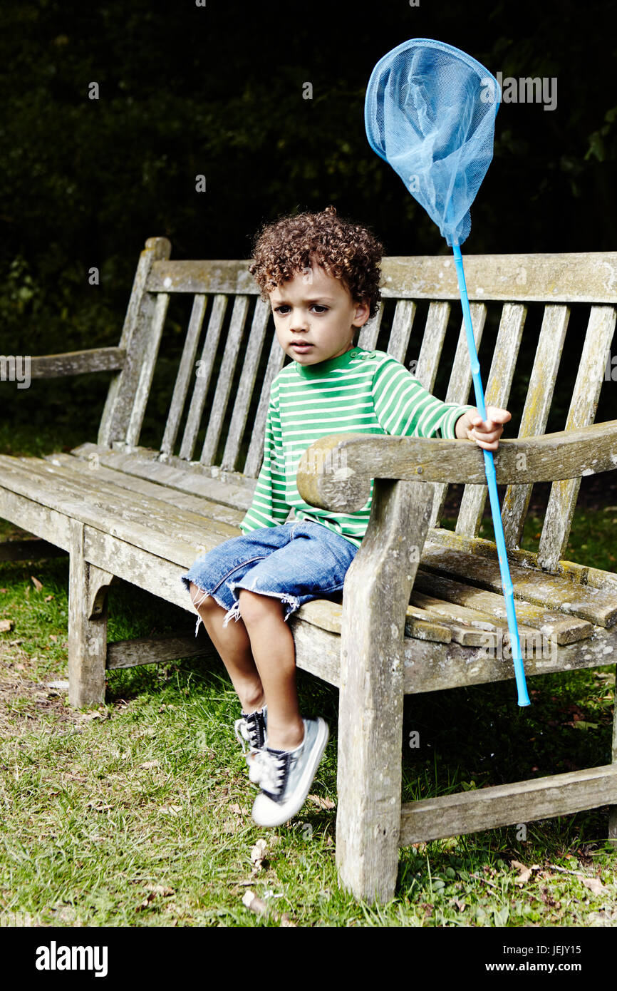 Boy on bench holding net Stock Photo - Alamy
