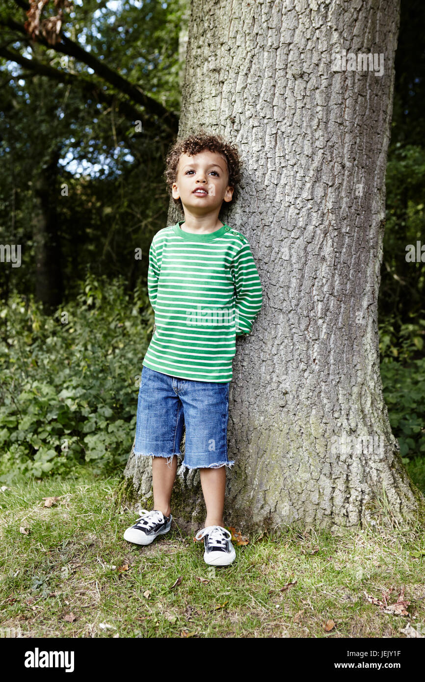 Boy in front of big tree Stock Photo - Alamy