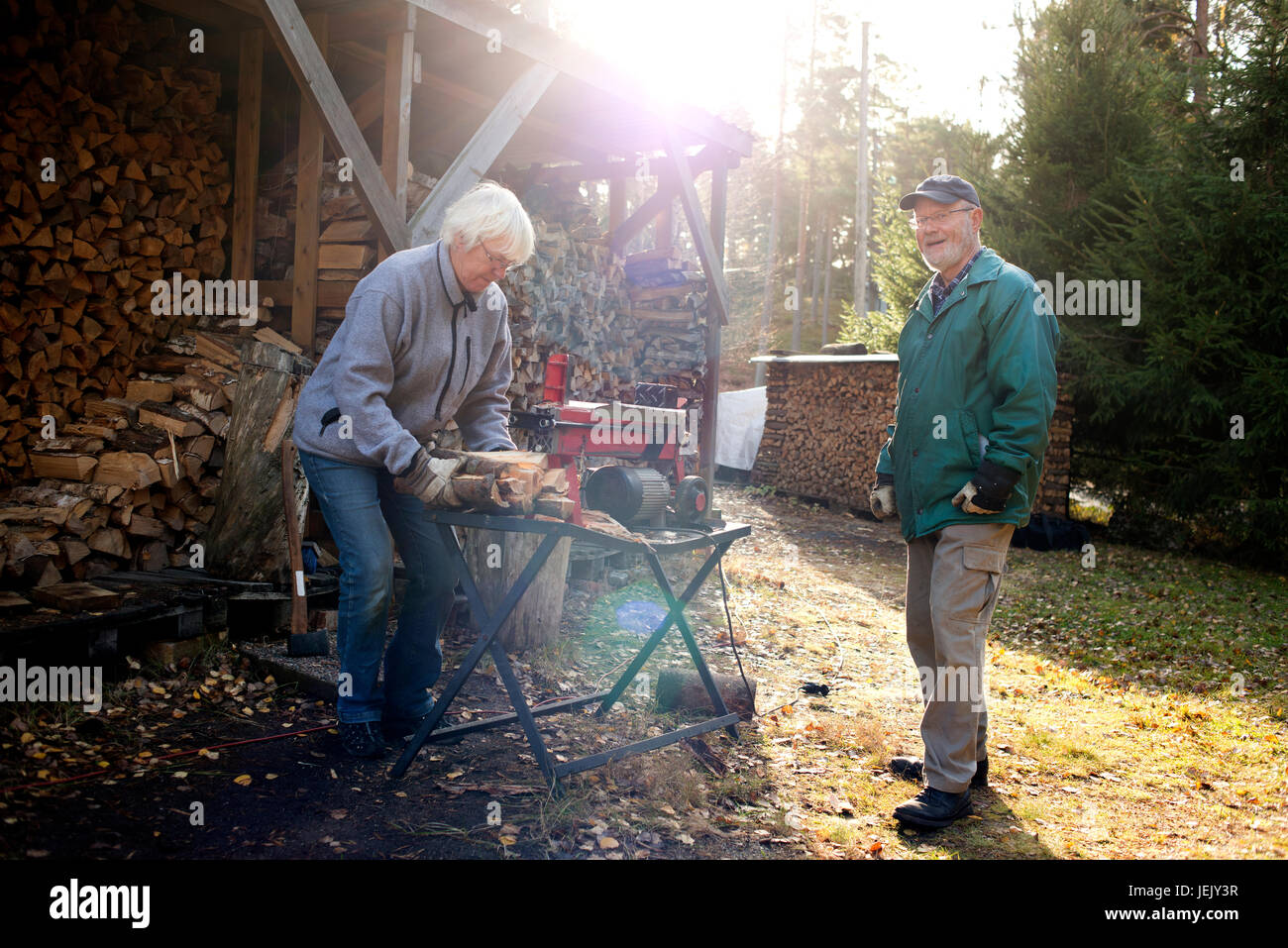 Senior couple cutting wood Stock Photo - Alamy