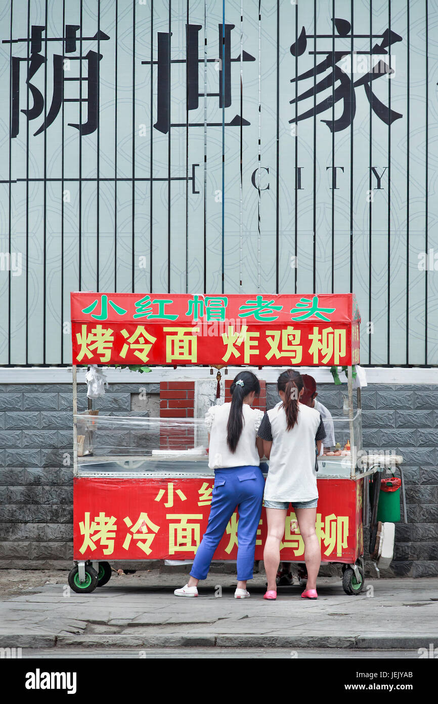 CHANGCHUN-CHINA-JULY 8. Two girls purchase street food. According to a ...