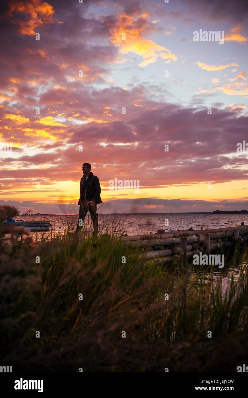 Man walking at sunset Stock Photo - Alamy
