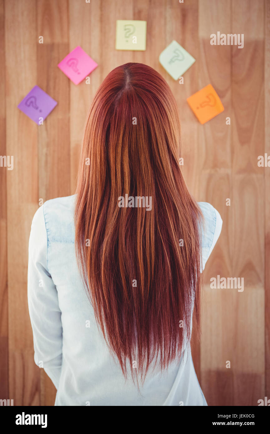 Rear view of hipster woman looking post-it Stock Photo - Alamy