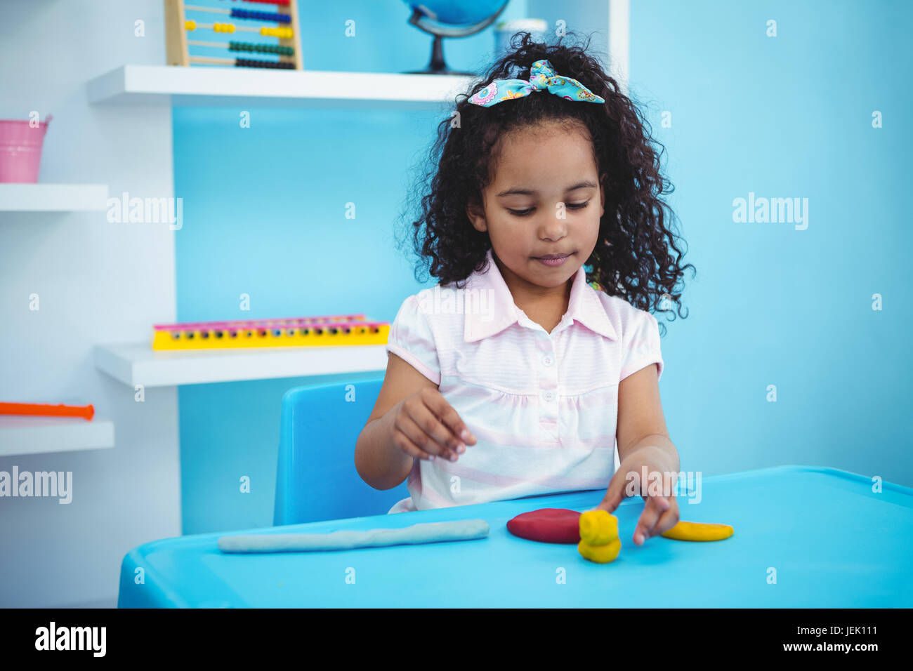Cute girl using modeling clay Stock Photo - Alamy