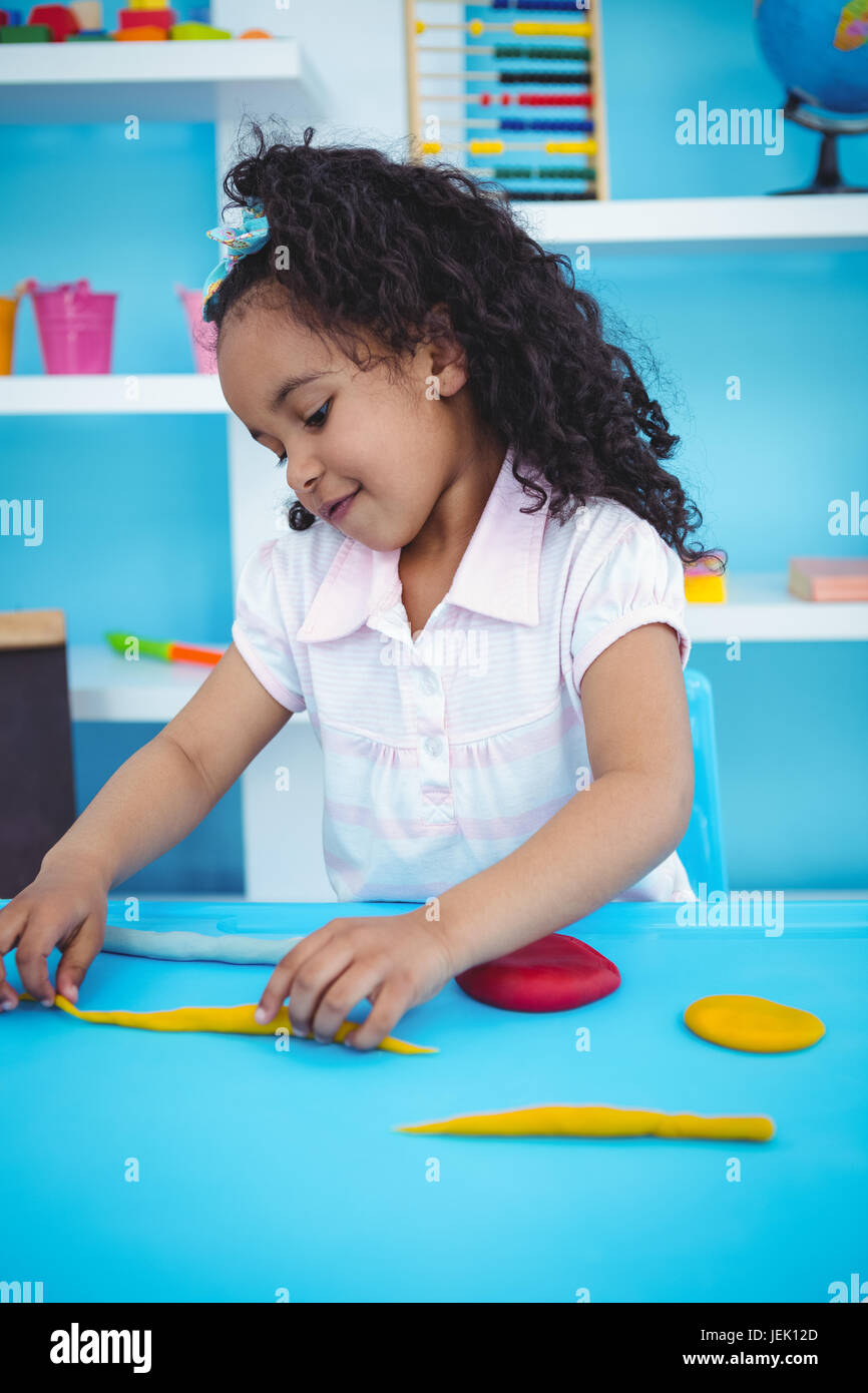 Cute girl playing with modeling clay Stock Photo - Alamy
