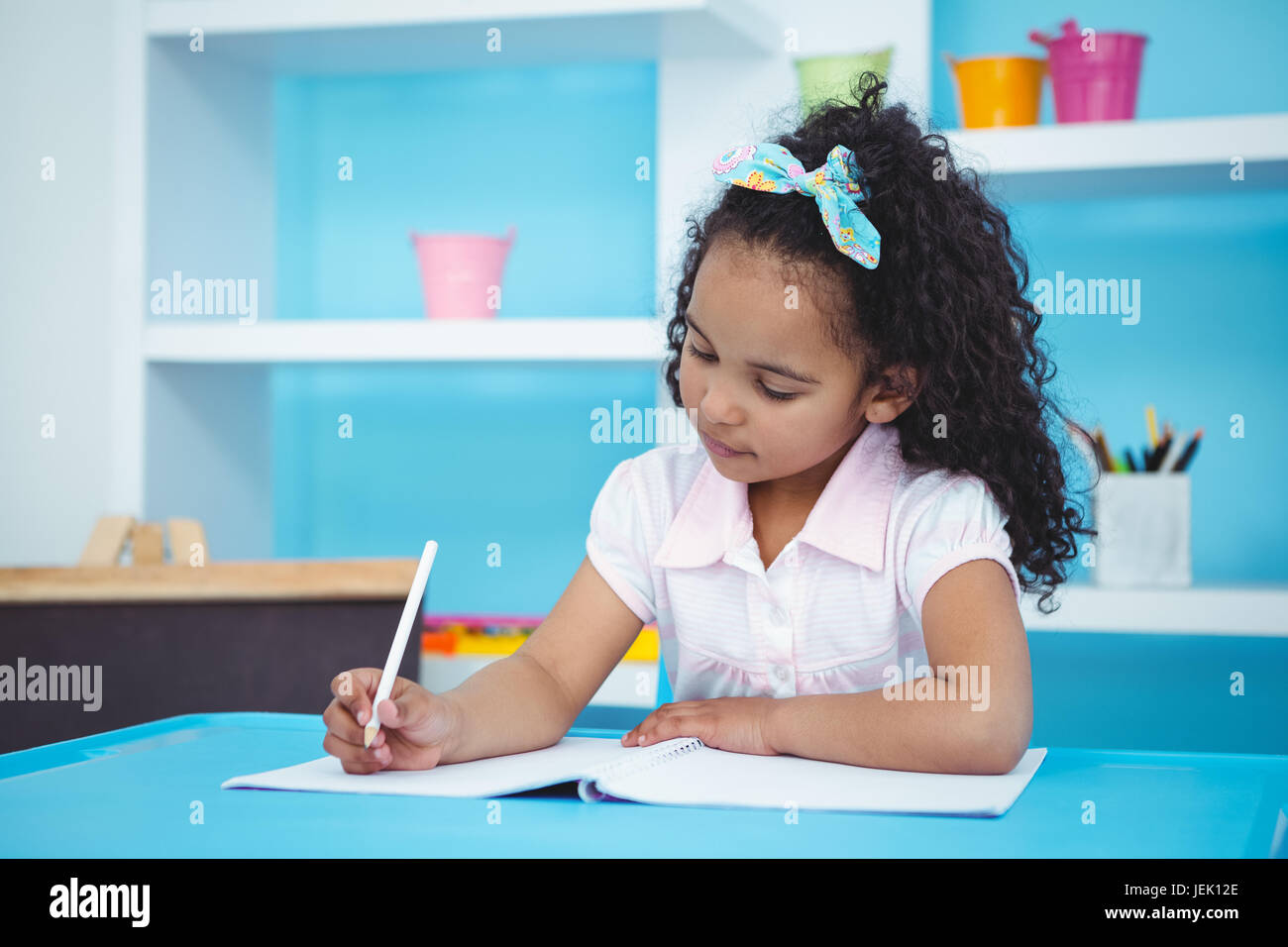 Cute girl writing on notebook Stock Photo - Alamy