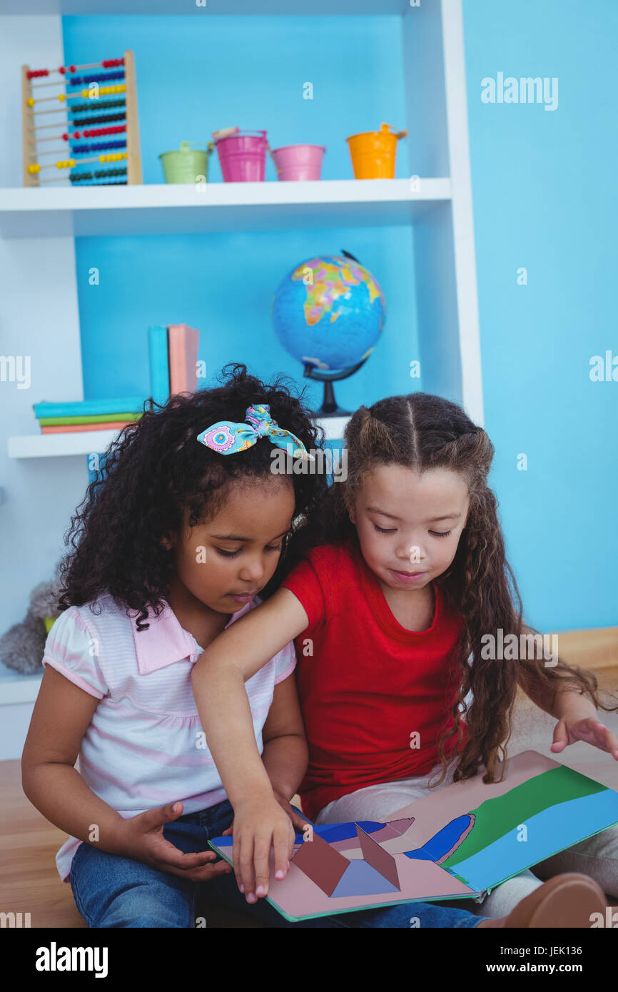 Cute girls holding a book Stock Photo - Alamy
