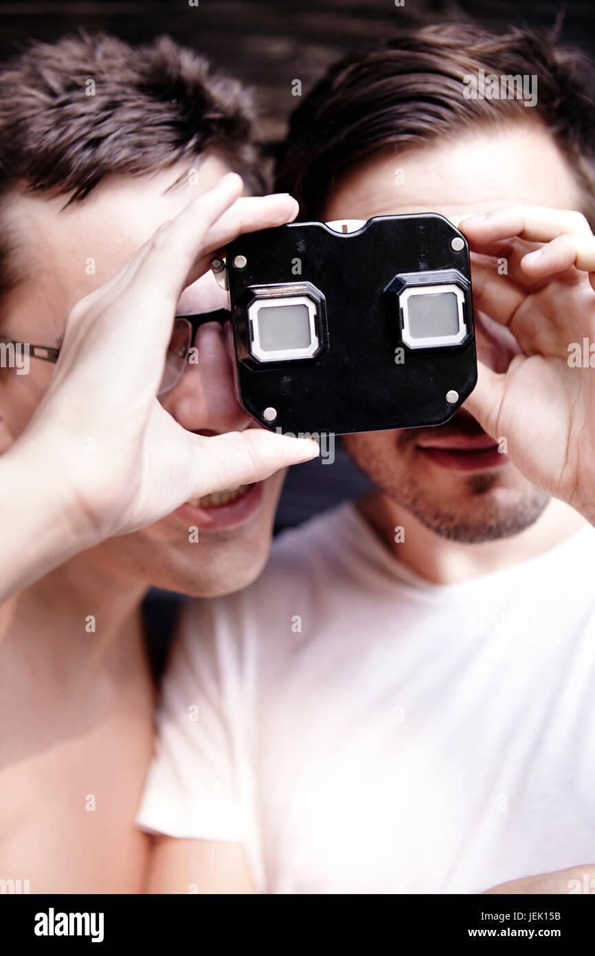 Young men looking through viewfinder Stock Photo - Alamy