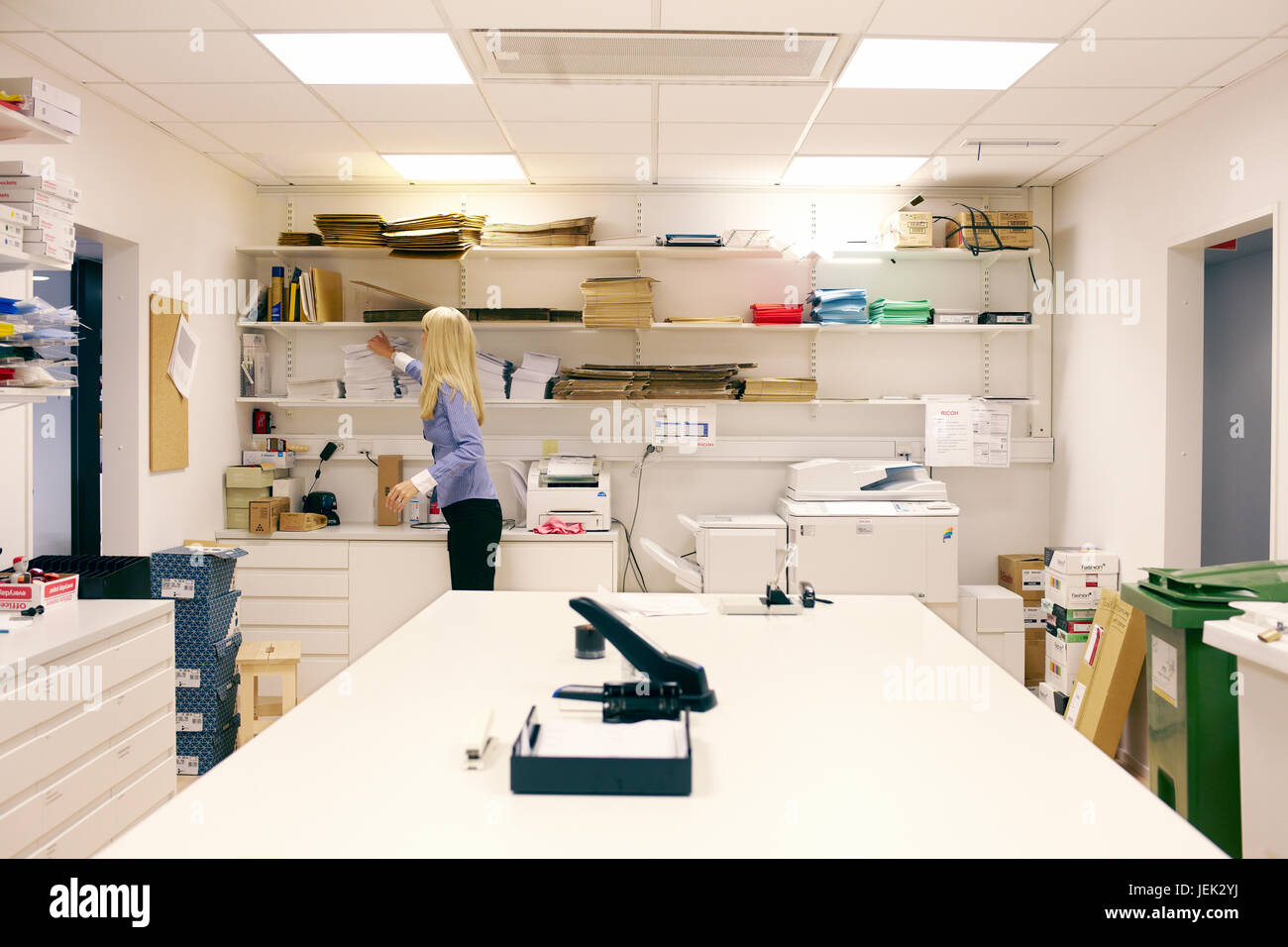 Woman in office storeroom Stock Photo - Alamy