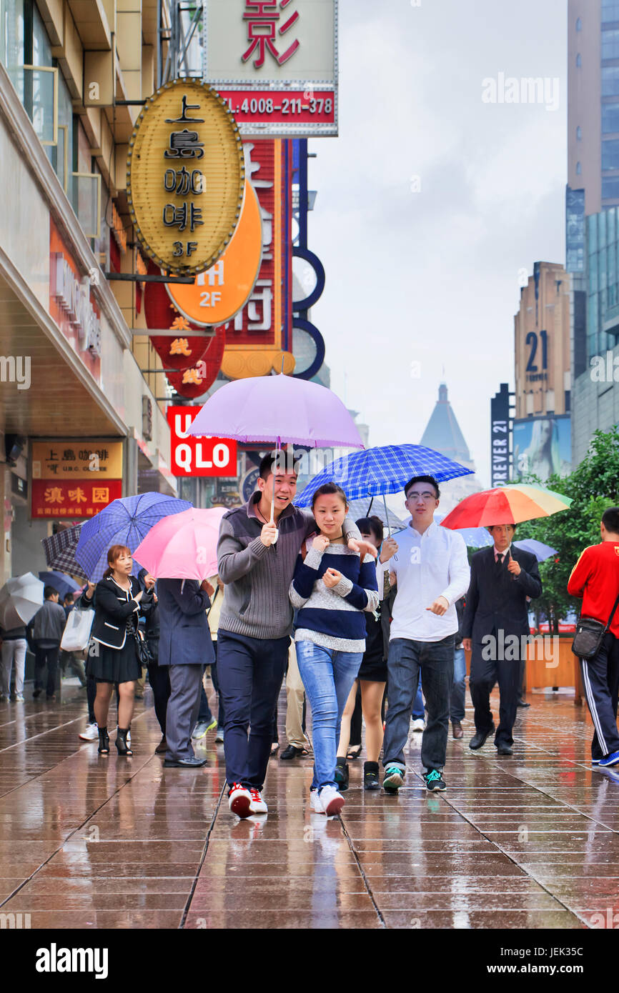 Shoppers with umbrella in wet Nanjing East Road. Shanghai has a humid ...