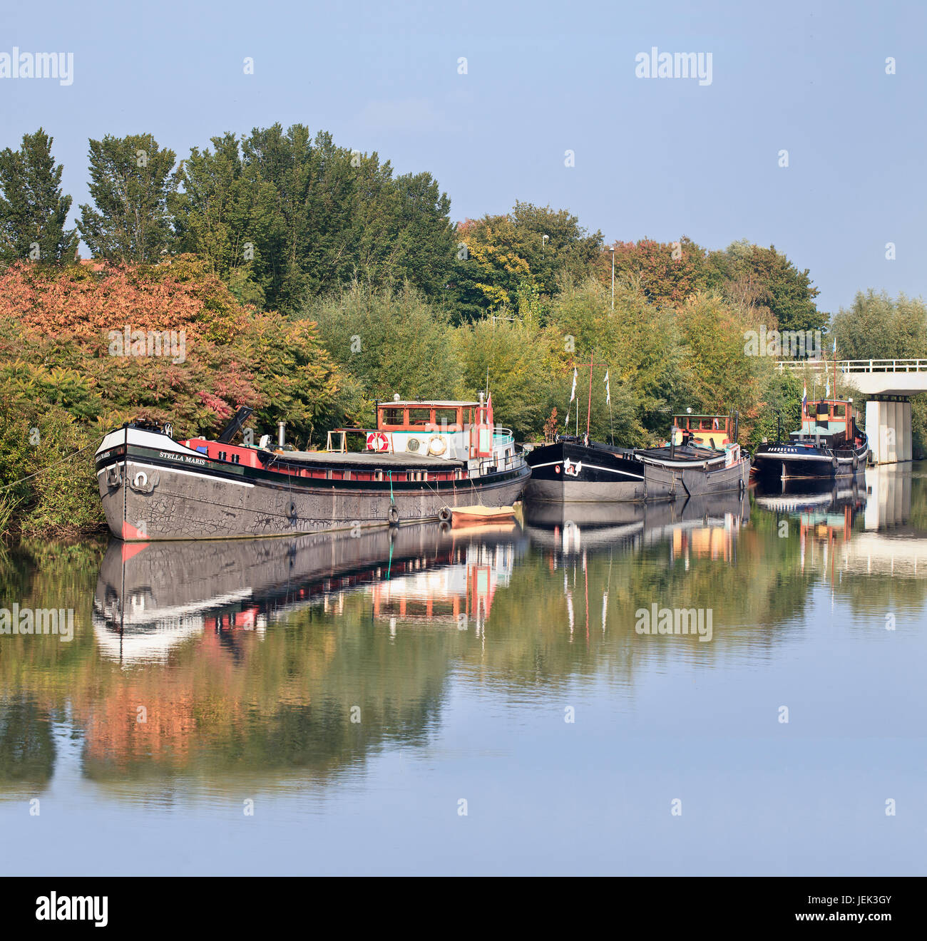 Old vessels moored in Pius Harbor with autumn color vegetation. These ...