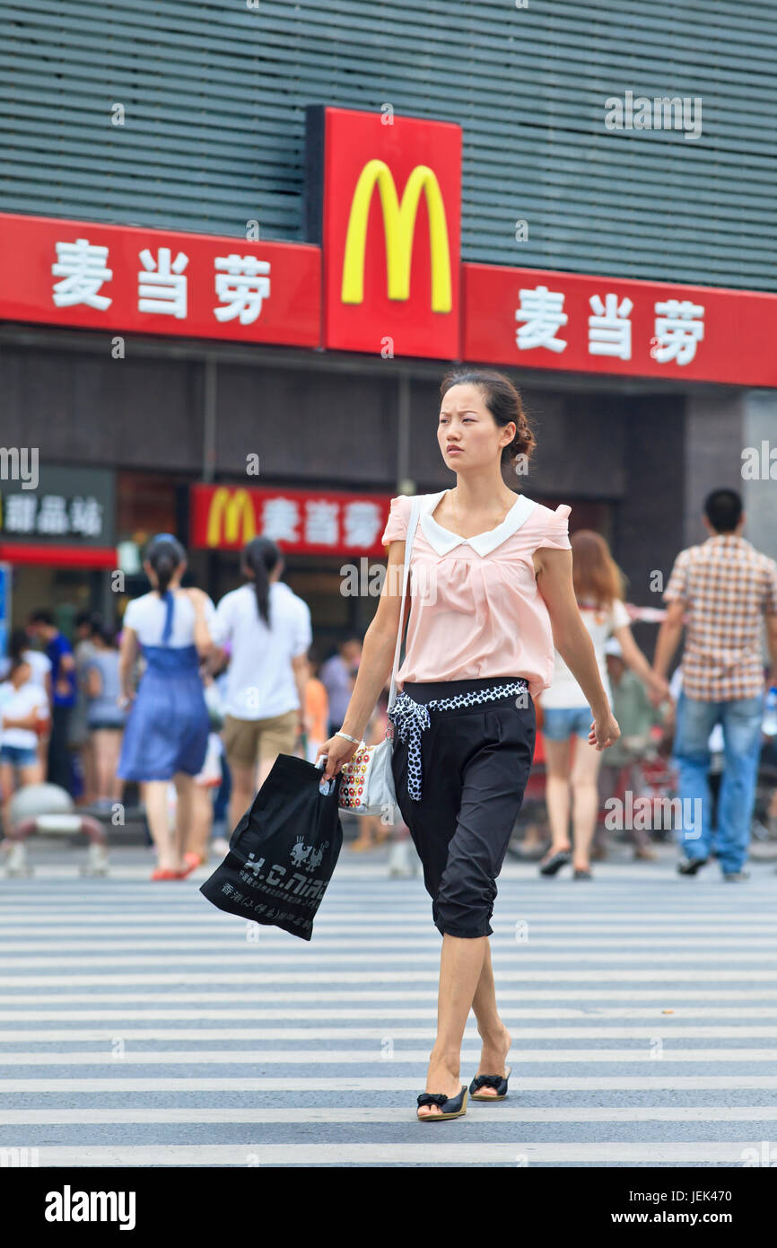 XIANG YANG-CHINA-JULY 3. Charming girl walks in front of McDonald. It ...