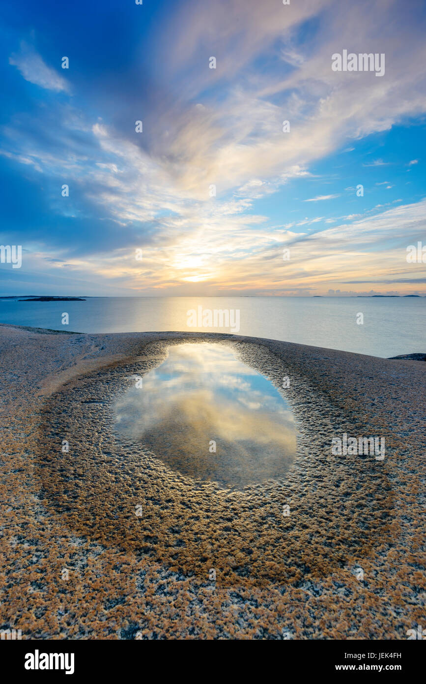 Evening sky reflecting in puddle Stock Photo - Alamy