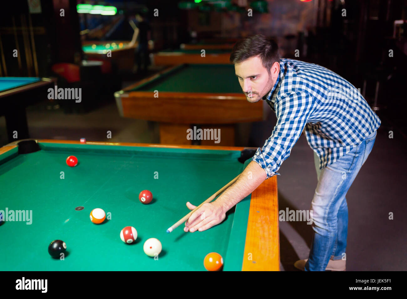 Hansome man playing pool in bar alone aiming Stock Photo - Alamy