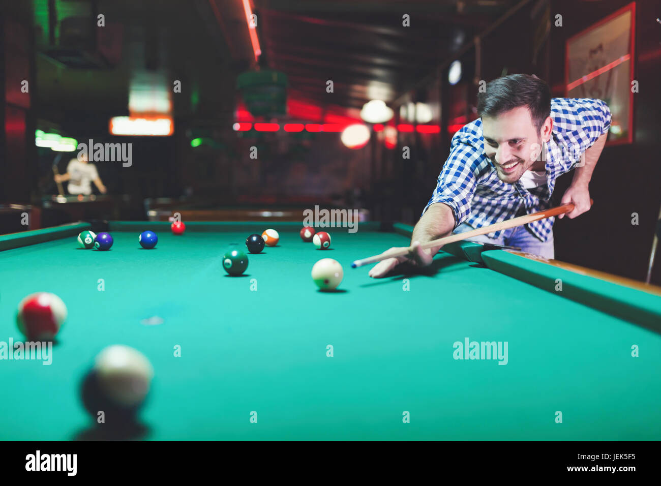 Hansome man playing pool in bar alone aiming Stock Photo - Alamy