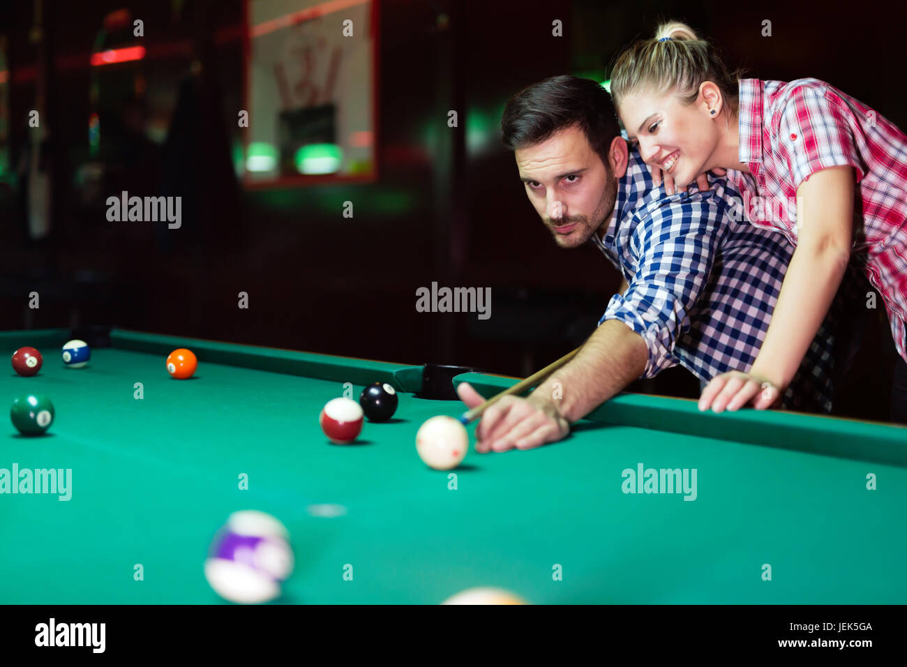 Young couple playing pool in bar while having night out in town Stock ...