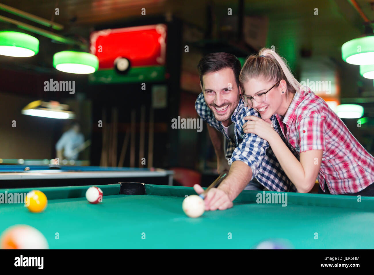 Young couple playing pool in bar while having night out in town Stock ...