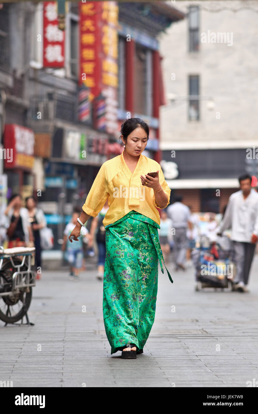 BEIJING-JUNE 9, 2015. Traditional dressed Chinese woman with smartphone ...