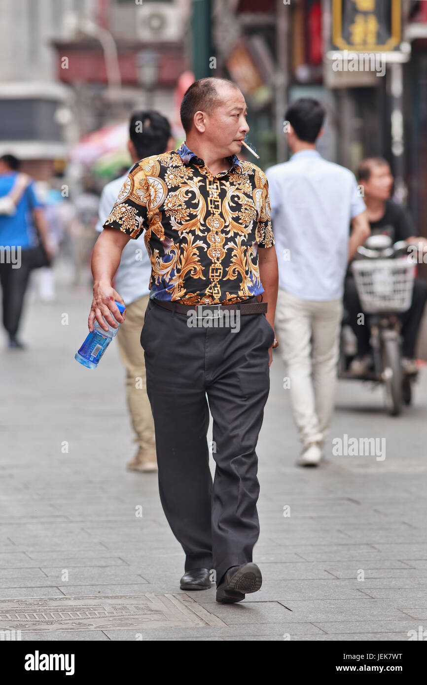 BEIJING-JUNE 9, 2015. Smoker walks in shopping street. China has more ...