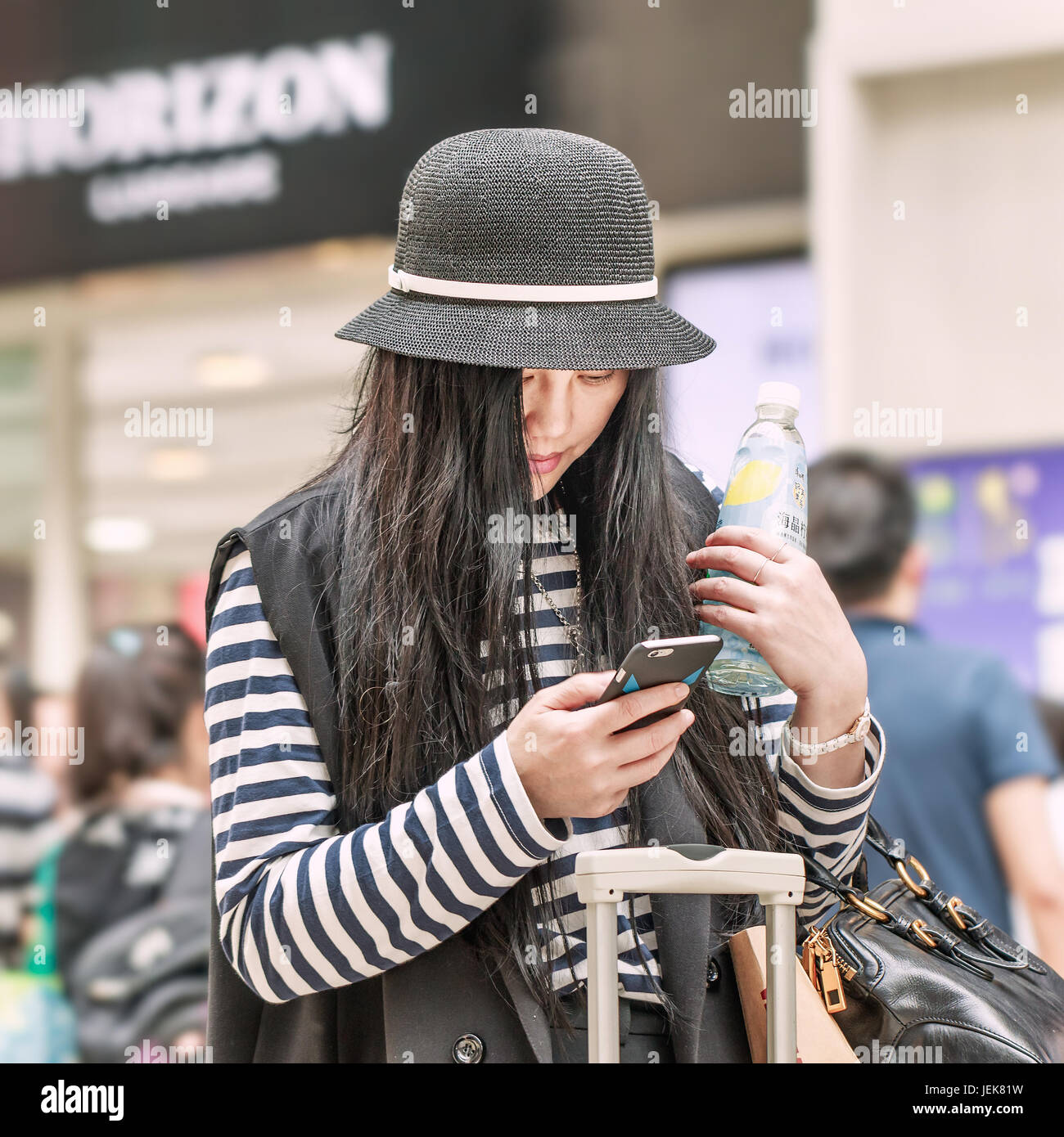 BEIJING-MAY 21, 2016. Fashionable young Chinese girl busy with ...