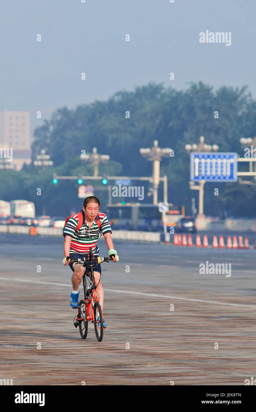 BEIJING-JUNE 1, 2013. Early commuter on foldable bike. In Beijing (over ...