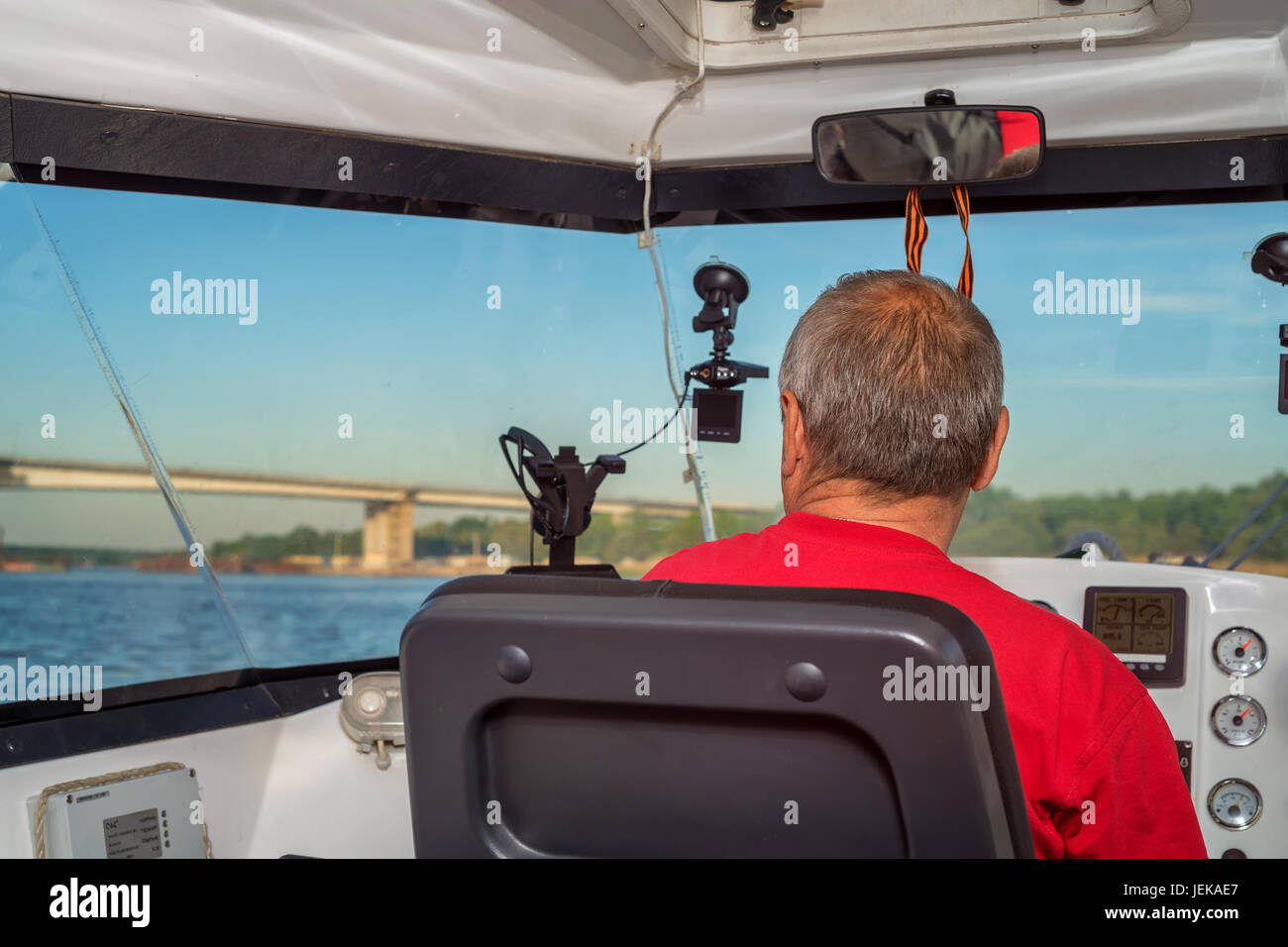 Back view of river boat driver Stock Photo - Alamy