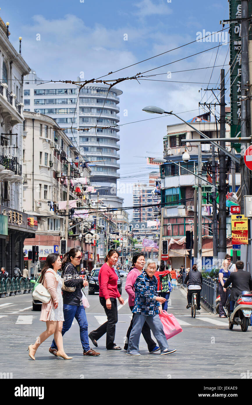 SHANGHAI-MAY 5, 2014. Women crossing street in dense area. Urban ...