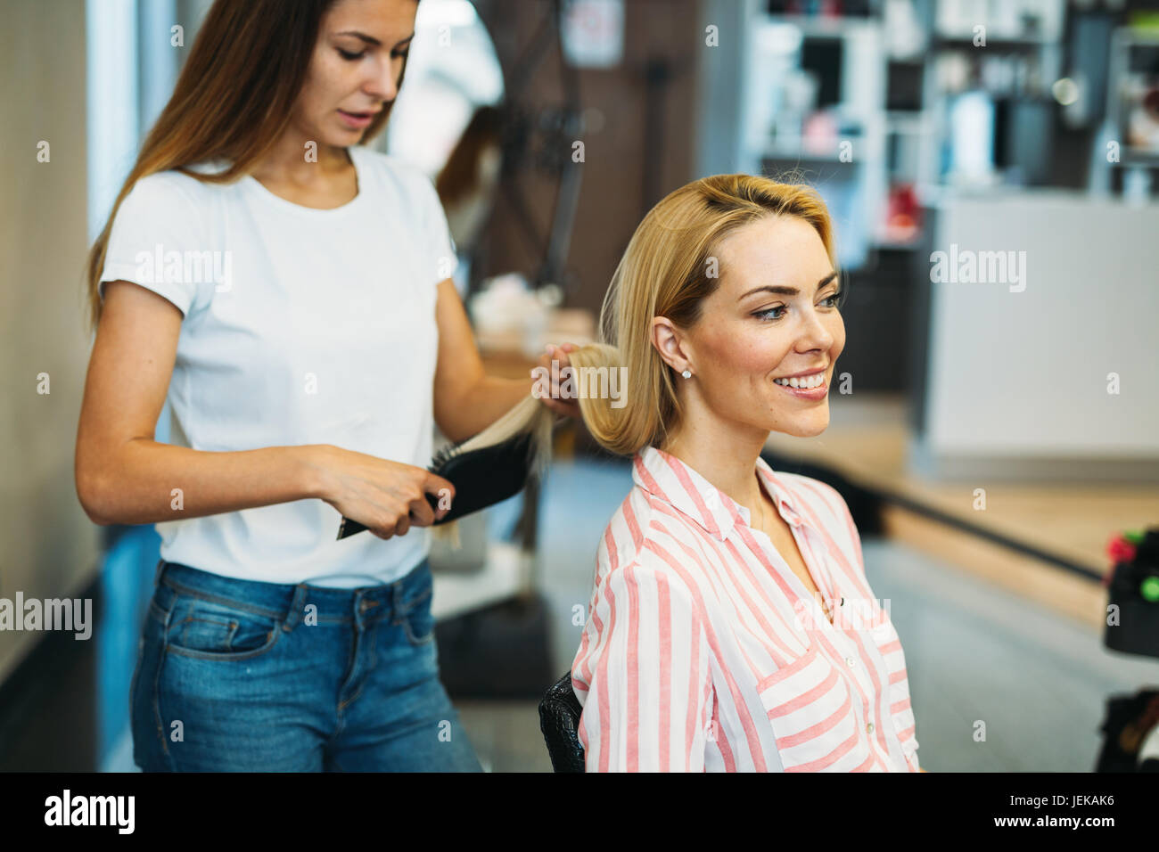 Portrait of beautiful young woman getting haircut in beauty salon Stock ...