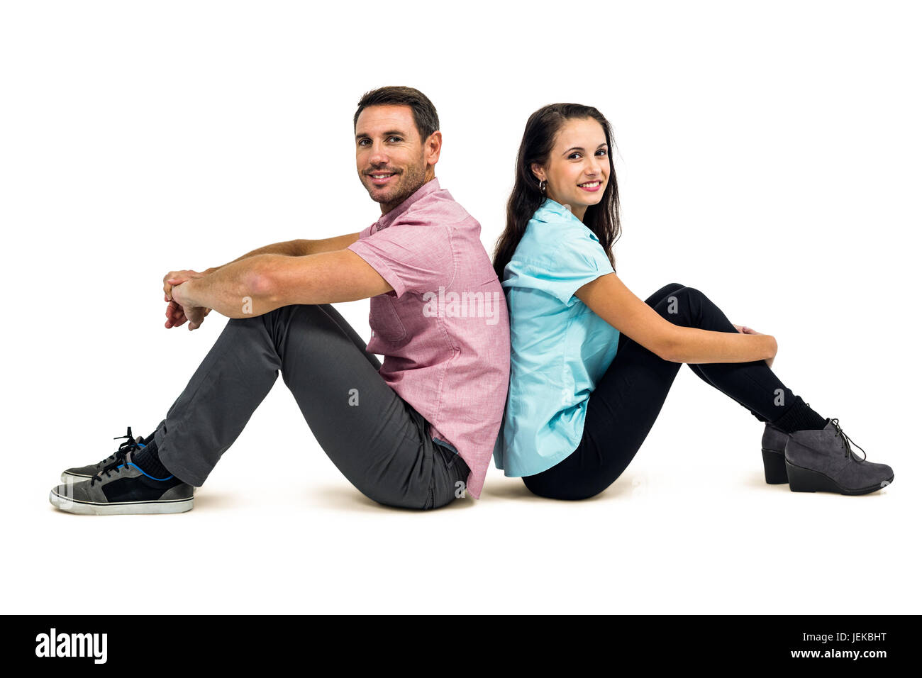 Portrait of couple sitting back to back Stock Photo - Alamy