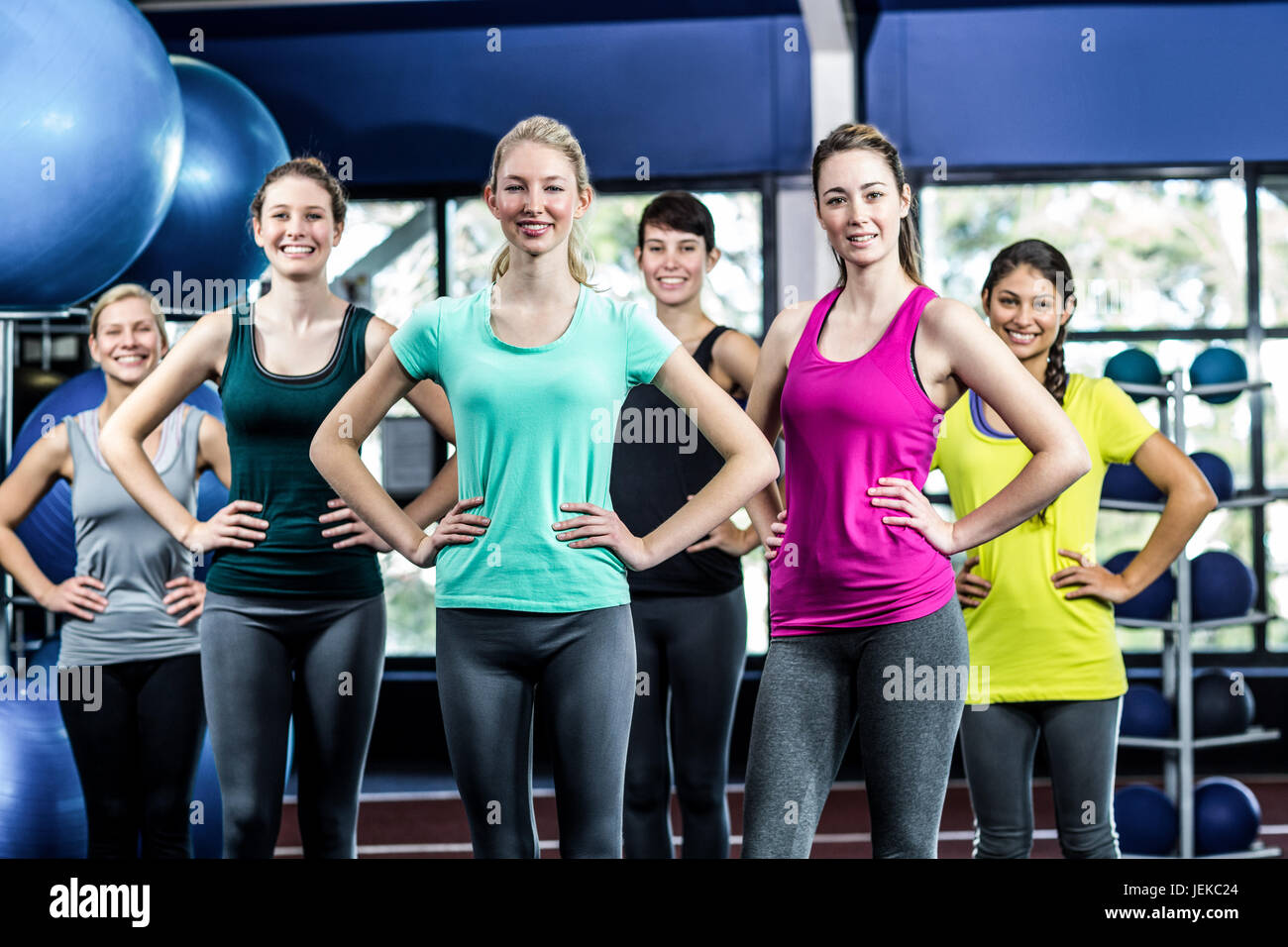 Fit smiling group with hands on hips Stock Photo - Alamy